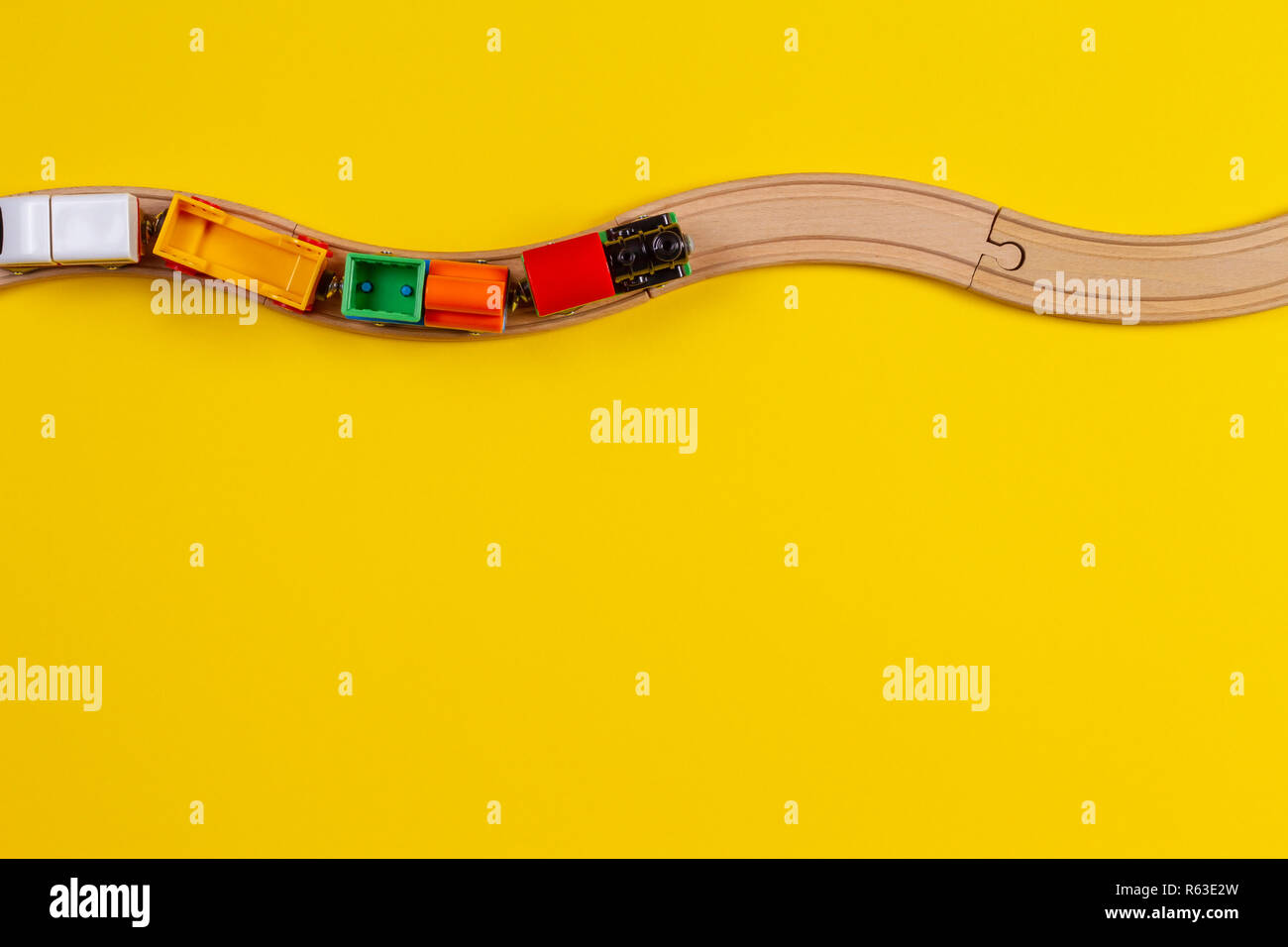 Toy trains and wooden rails on yellow color background Stock Photo - Alamy