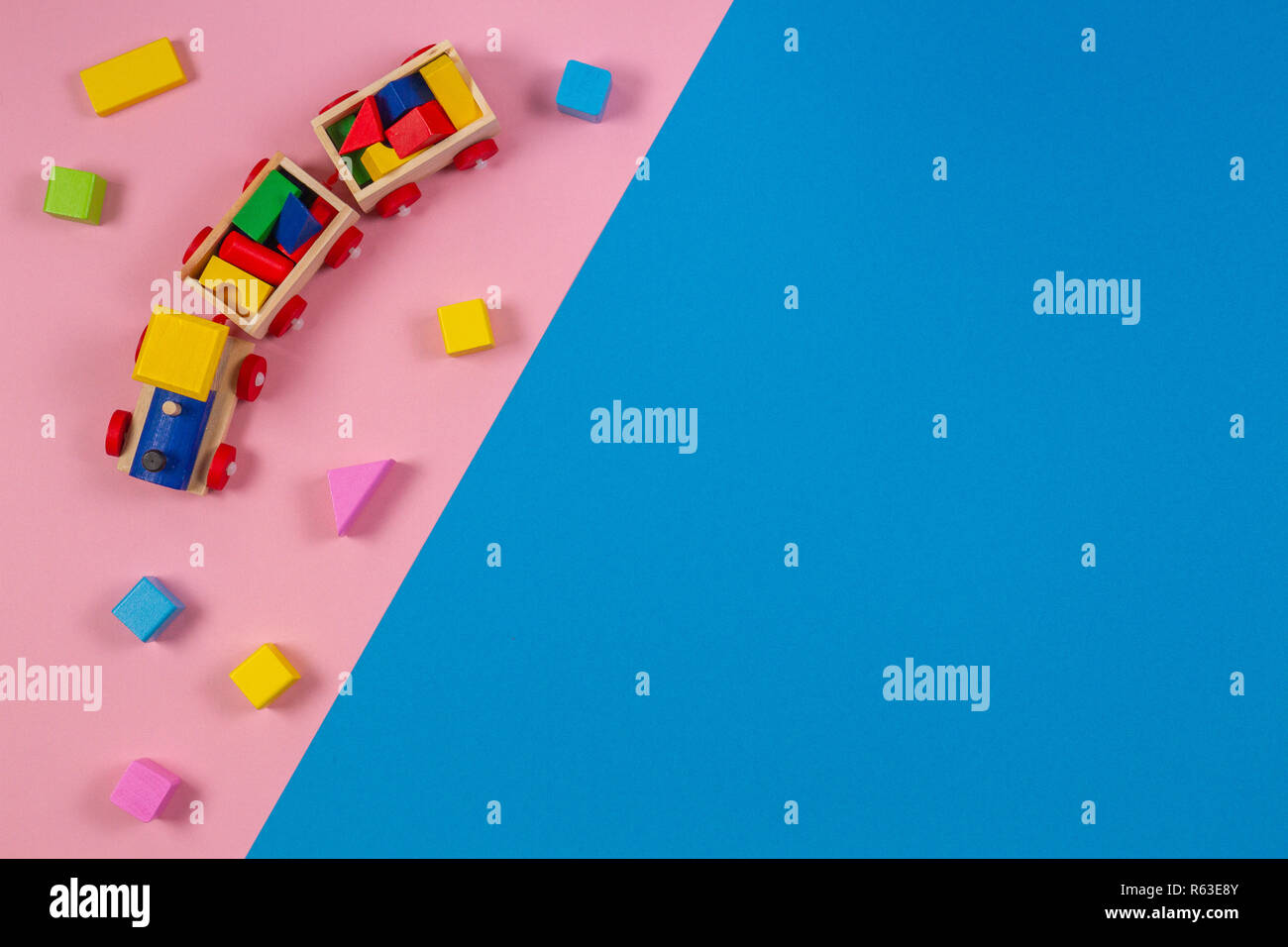 Toy background. Wooden toy train with colorful cubes on pink and blue ...