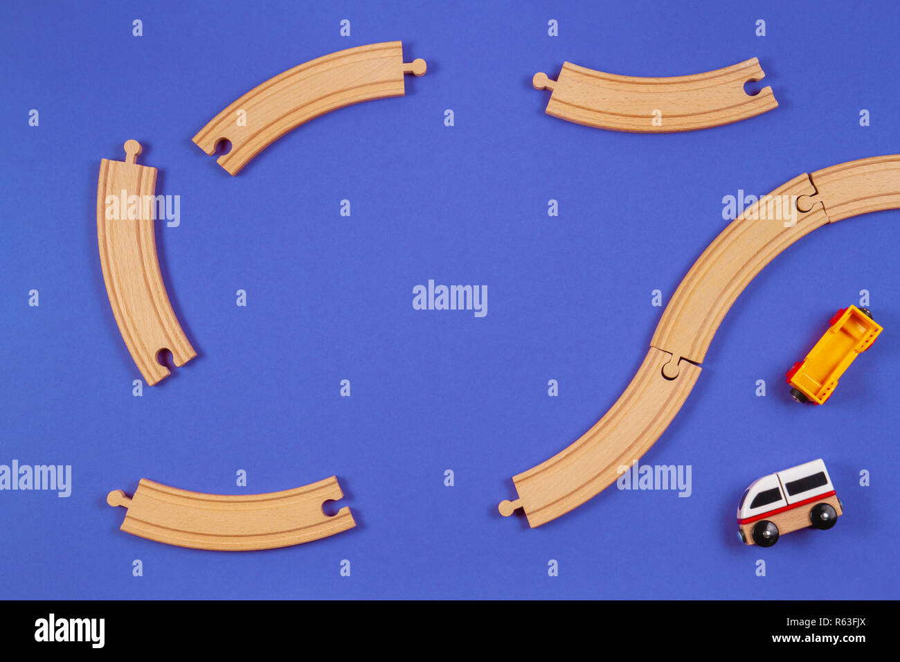 Toy train and wooden rails pieces on blue color background Stock Photo ...