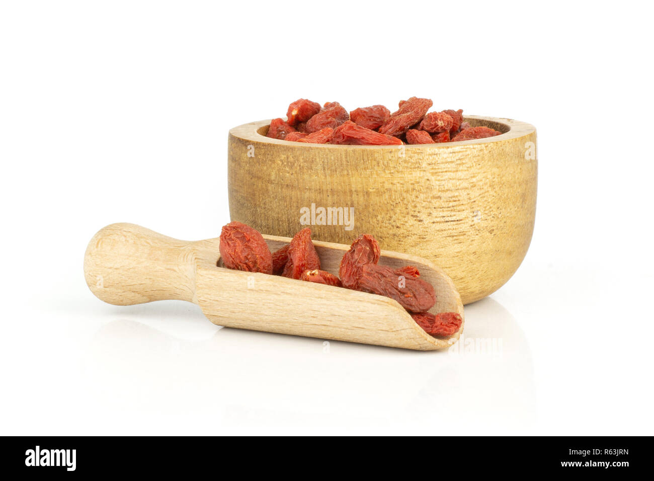 Lot of whole dried red goji berries in a light scoop with wooden bowl ...