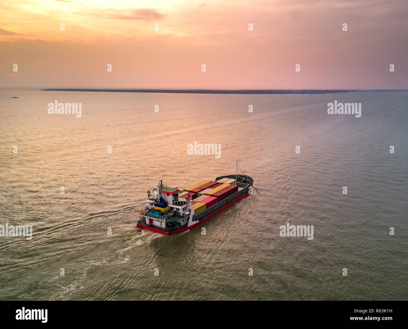 Medium container ship at estuary Stock Photo - Alamy