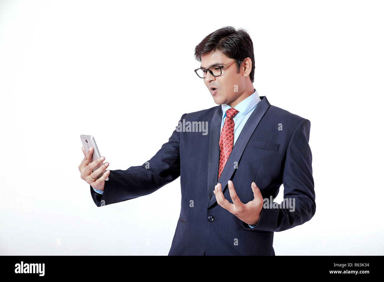 Young Indian businessman holding mobile in hand Stock Photo - Alamy