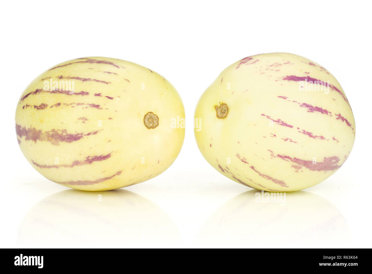 Group of two whole ripe light yellow fresh striped pepino melon ...