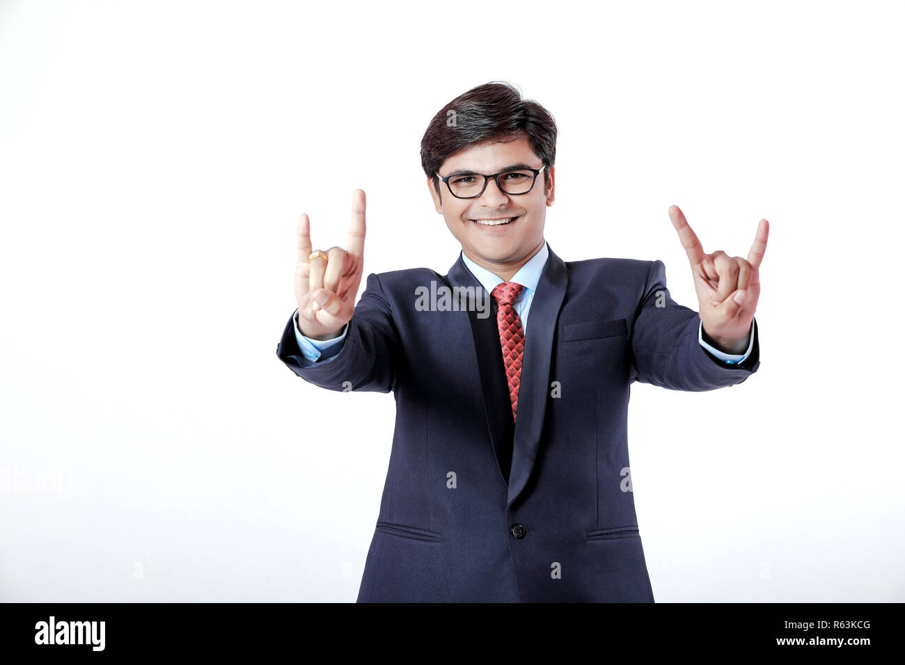 Young businessman doing the horn sign over white background Stock Photo ...