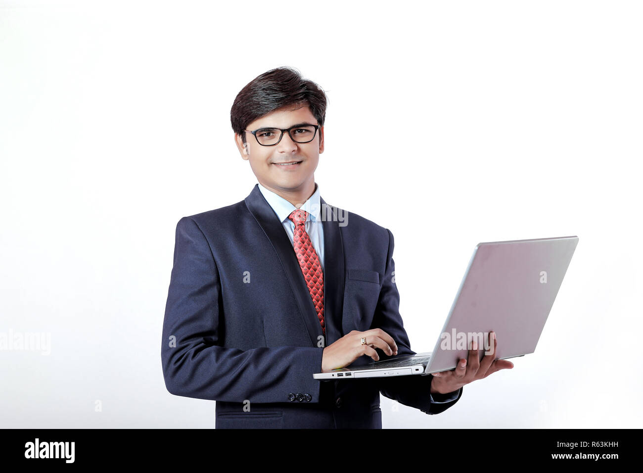 Young Indian businessmen using laptop over isolated background Stock ...