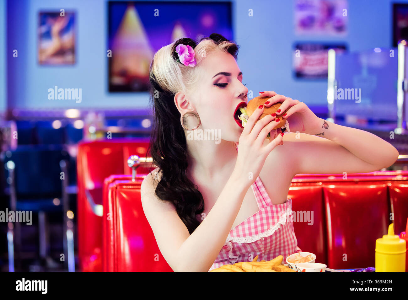 Portrait of a young Pin Up, front view, eating his hamburger Stock ...