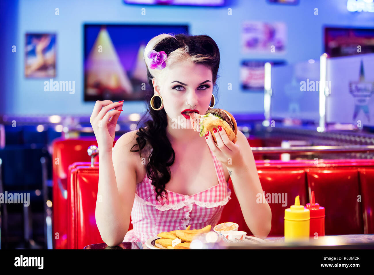 Portrait of a young Pin Up, front view, eating his hamburger Stock ...