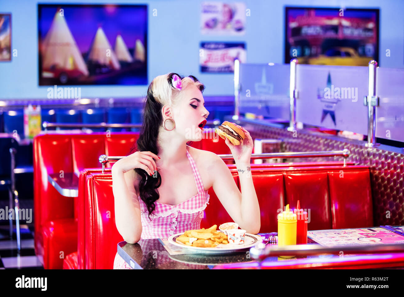 Portrait of a young Pin Up, front view, eating his hamburger Stock ...