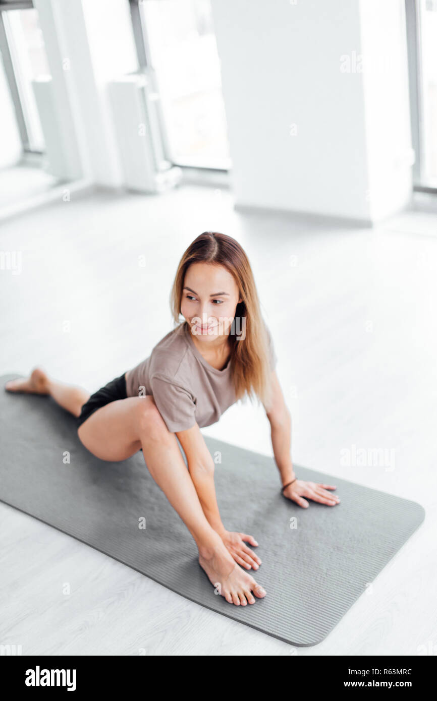 cheerful talented girl learning to do a side split at gym. yoga classes ...