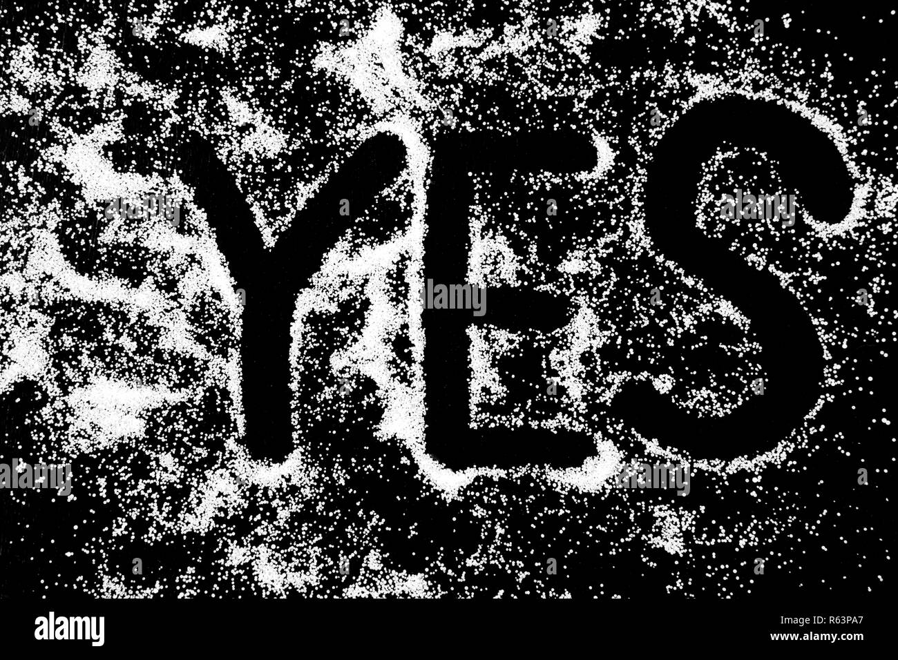 Yes word symbol drawing by finger on white snow salt powder on black ...