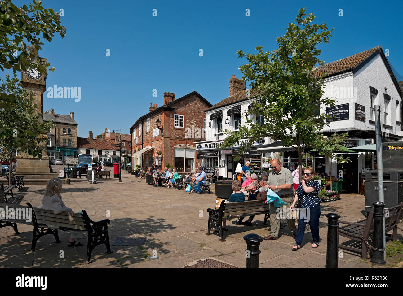 People relaxing in the summer outside shops stores in the town centre ...