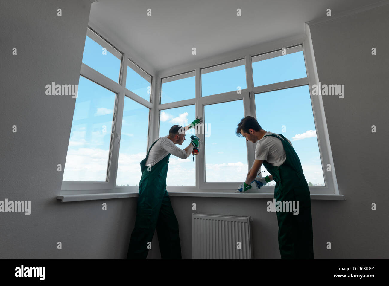 Two men are repairing home Stock Photo - Alamy