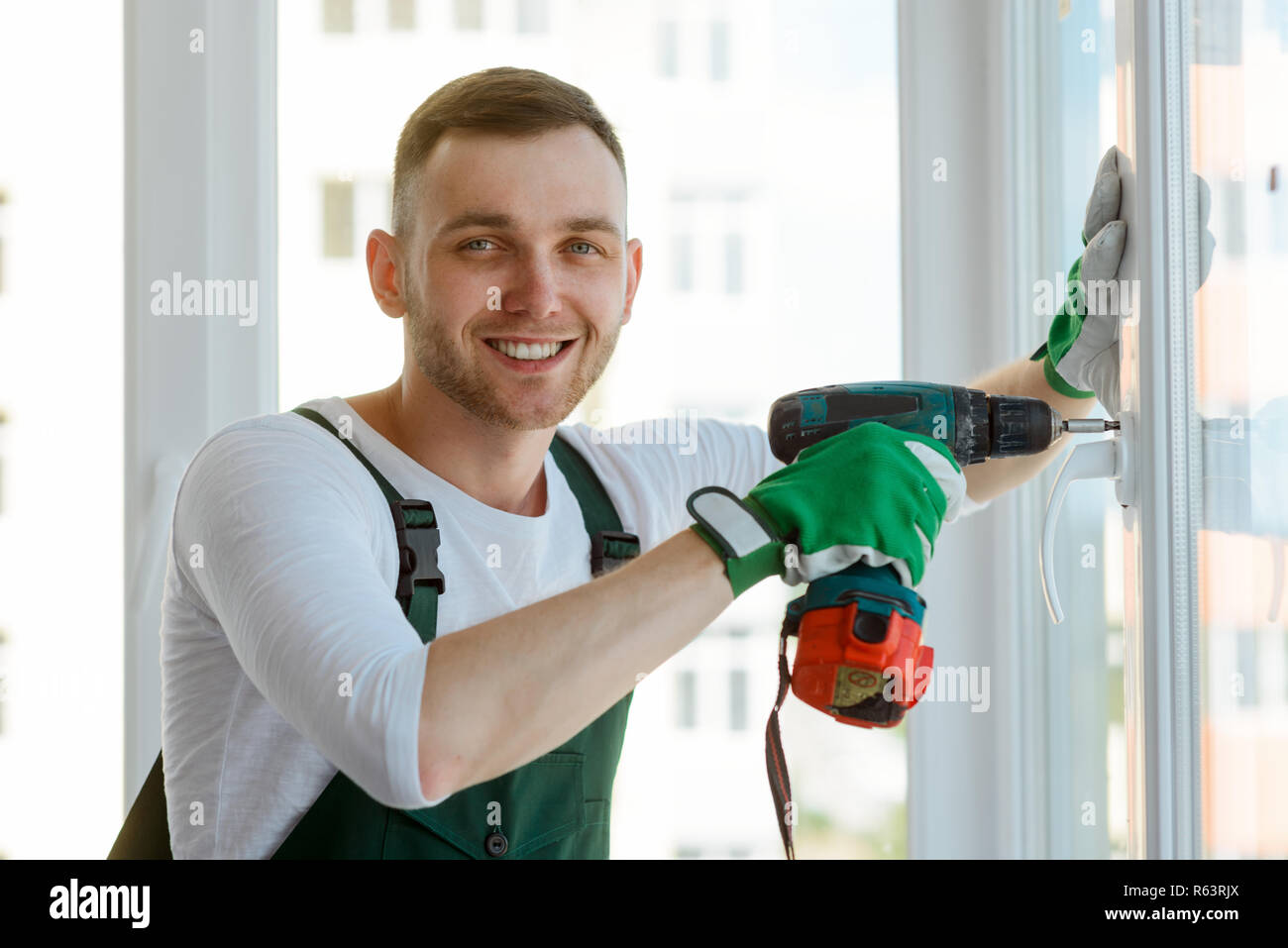 Smiling workman with a drill hi-res stock photography and images - Alamy