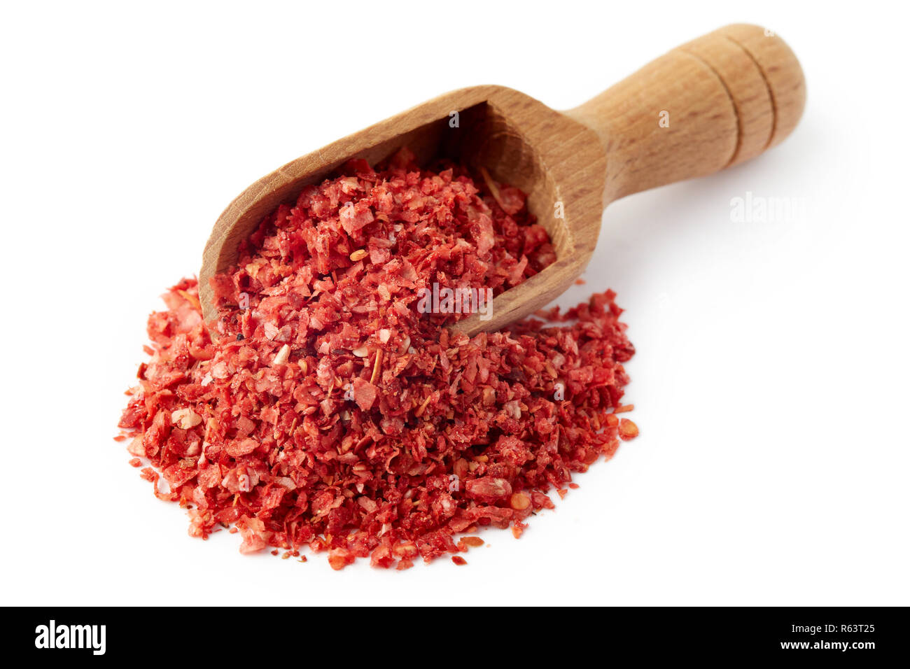 Dried chopped chili pepper in wooden scoop isolated on white background ...