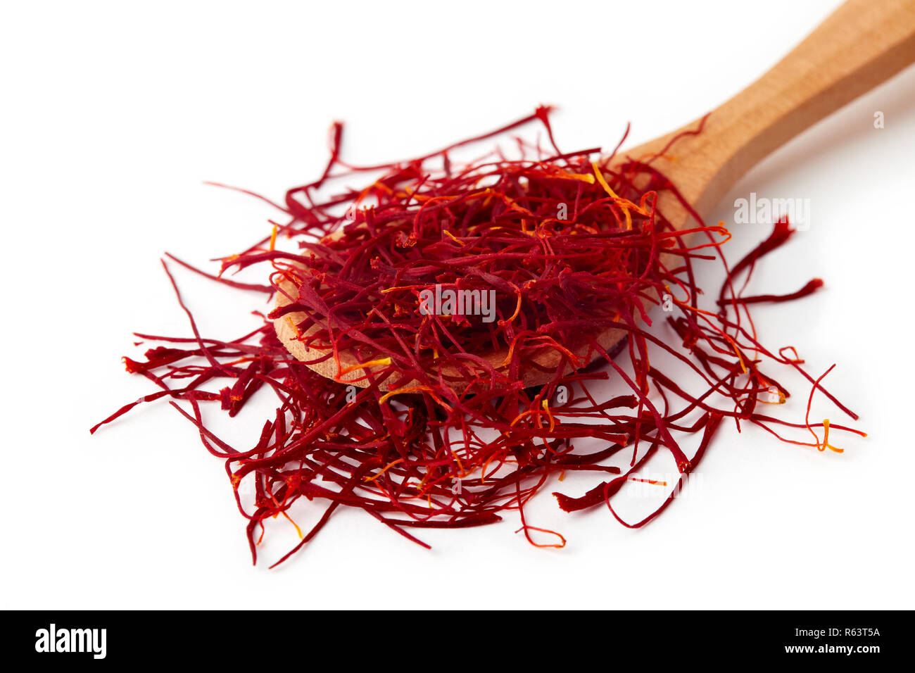Saffron spice threads (strands) in wooden spoon isolated on white ...