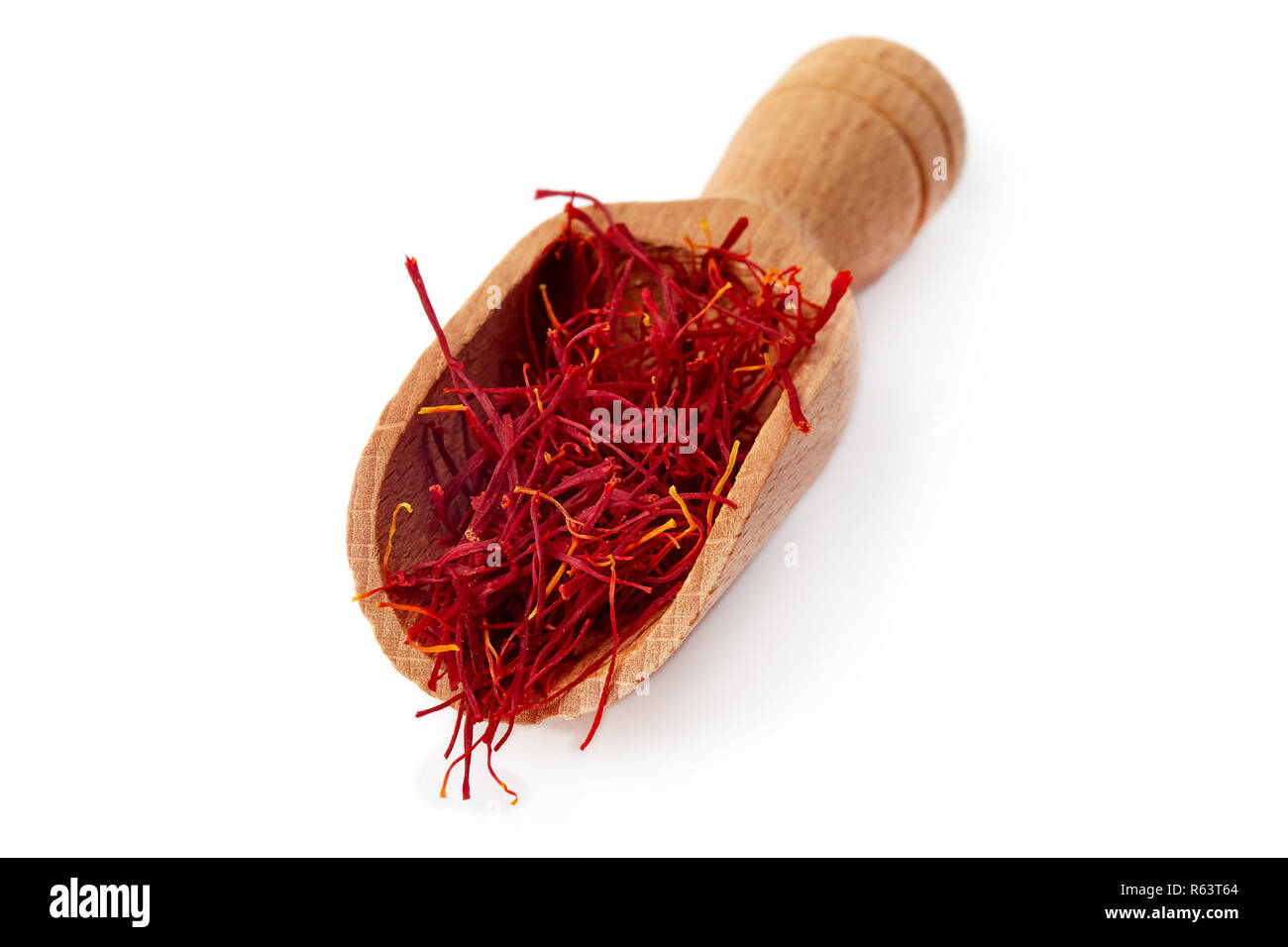Saffron spice threads (strands) in wooden scoop isolated on white ...