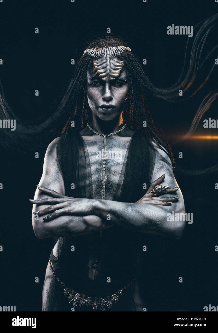 Young woman in image of humanoid and extraterrestrial alien with horns ...