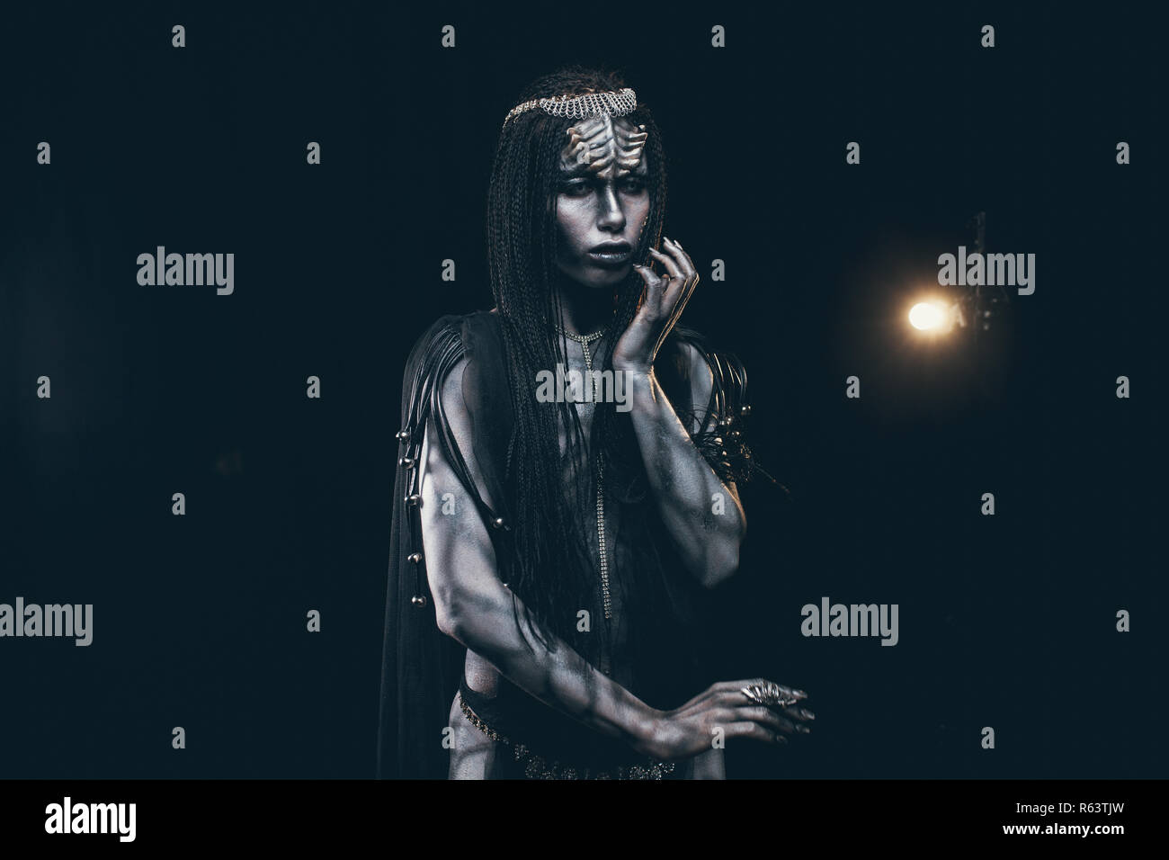 Young woman in image of humanoid and extraterrestrial alien with horns ...