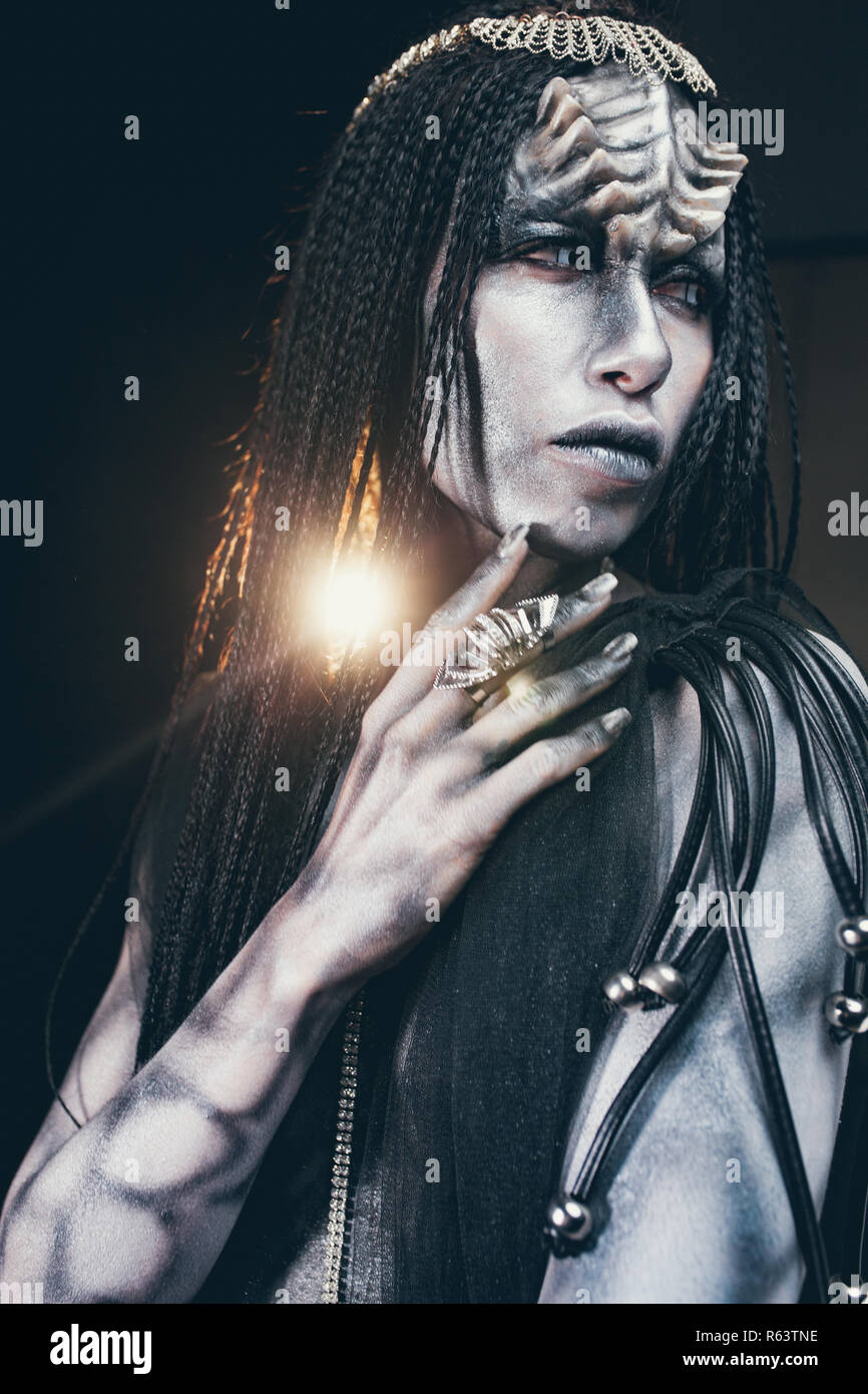 Young woman in image of humanoid and extraterrestrial alien with horns ...