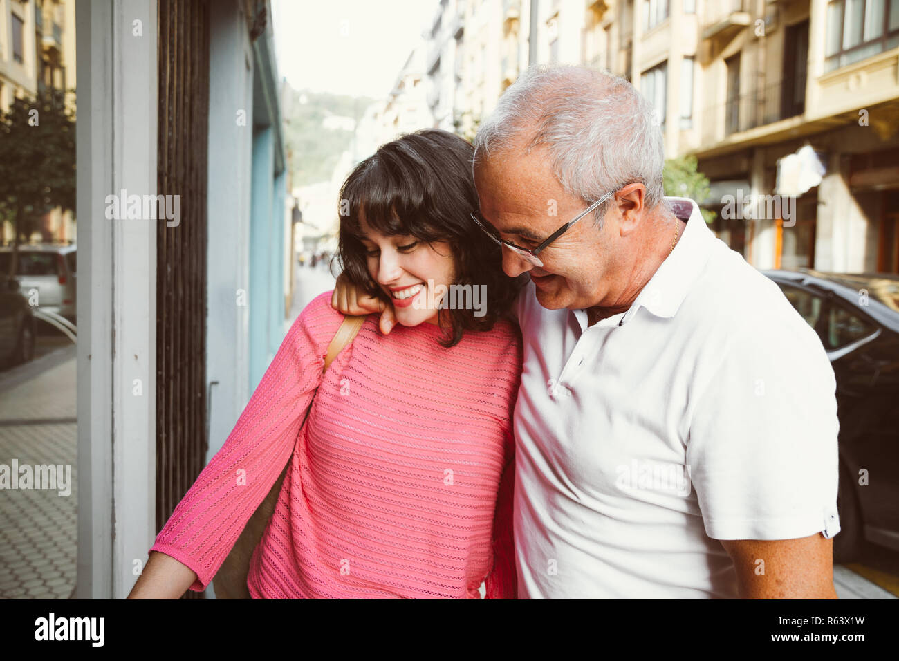 Mature father and young daughter looking at shop windows on the street ...