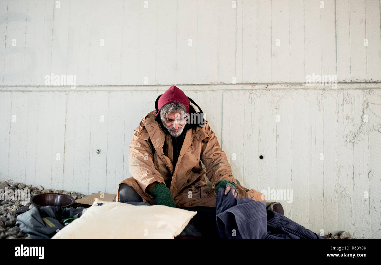 Homeless Beggar Man Sitting Outdoors In City Asking For Money Donation