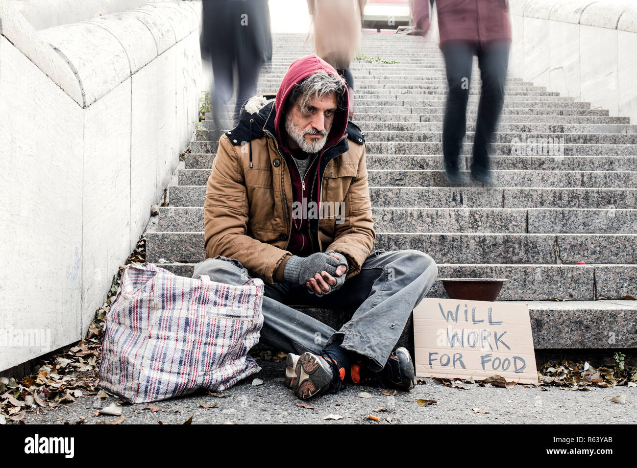 Homeless beggar man sitting outdoors in city asking for money donation ...