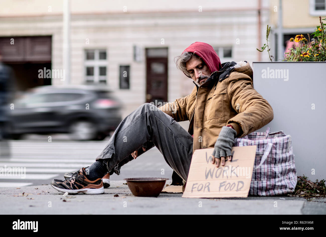 Homeless beggar man sitting outdoors in city asking for money donation ...