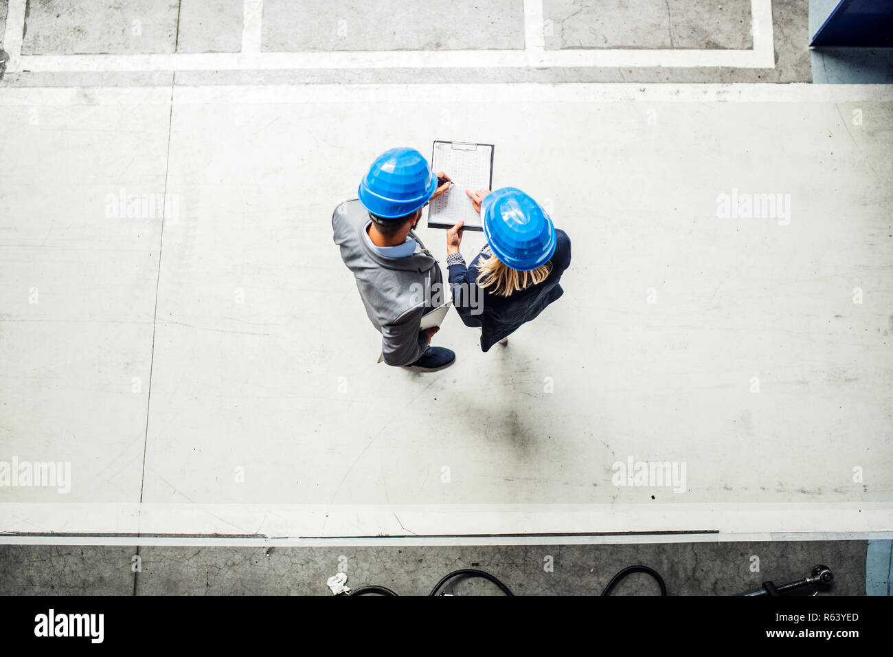 A top view of an industrial man and woman engineer with clipboard in a ...