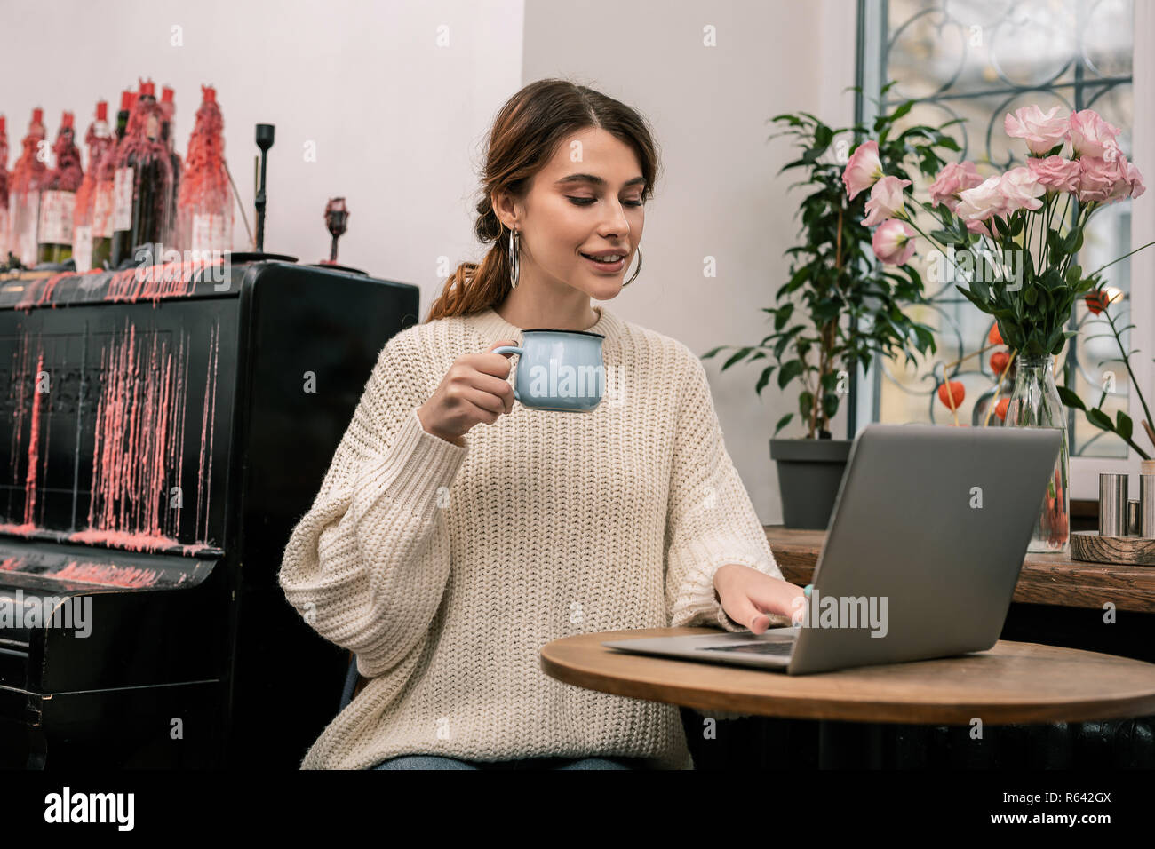 Woman drinking cocoa while working in a cafe Stock Photo - Alamy