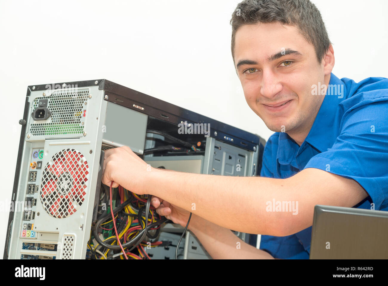 Young technician working on broken computer in his office Stock Photo ...