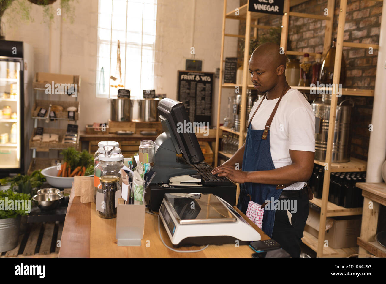 Male staff working on computer at counter Stock Photo - Alamy