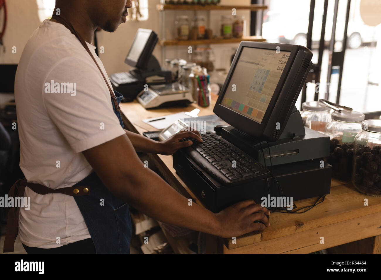 Male staff working on computer at counter Stock Photo - Alamy