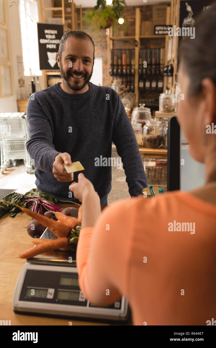 Customer making payment with credit card at counter Stock Photo - Alamy