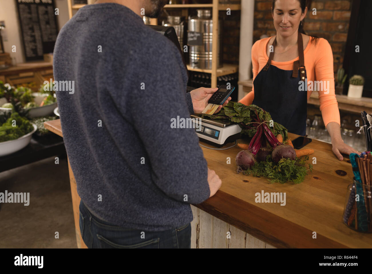Customer making payment at counter Stock Photo - Alamy