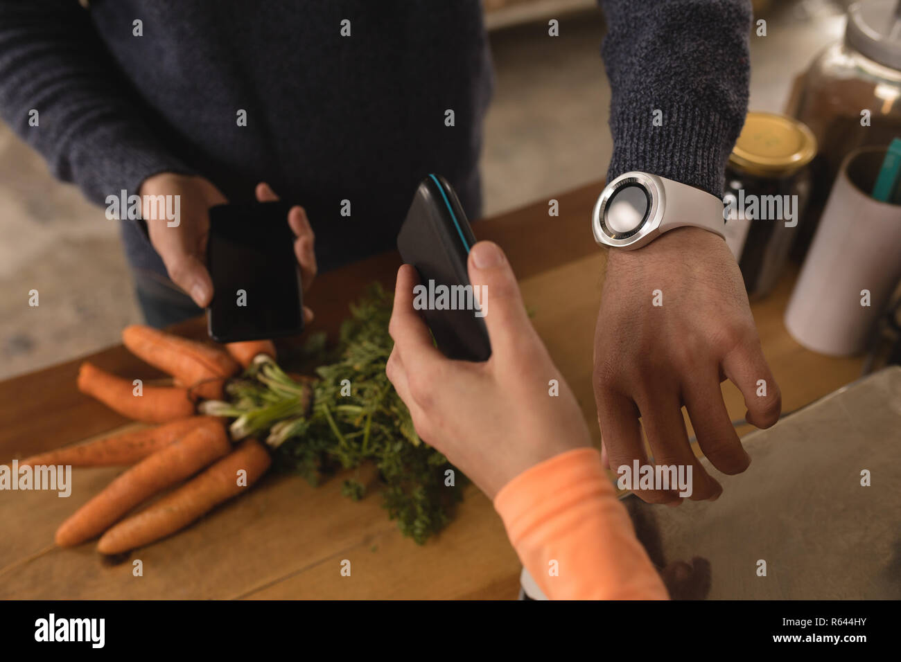 Customer making payment through smartwatch at counter Stock Photo - Alamy