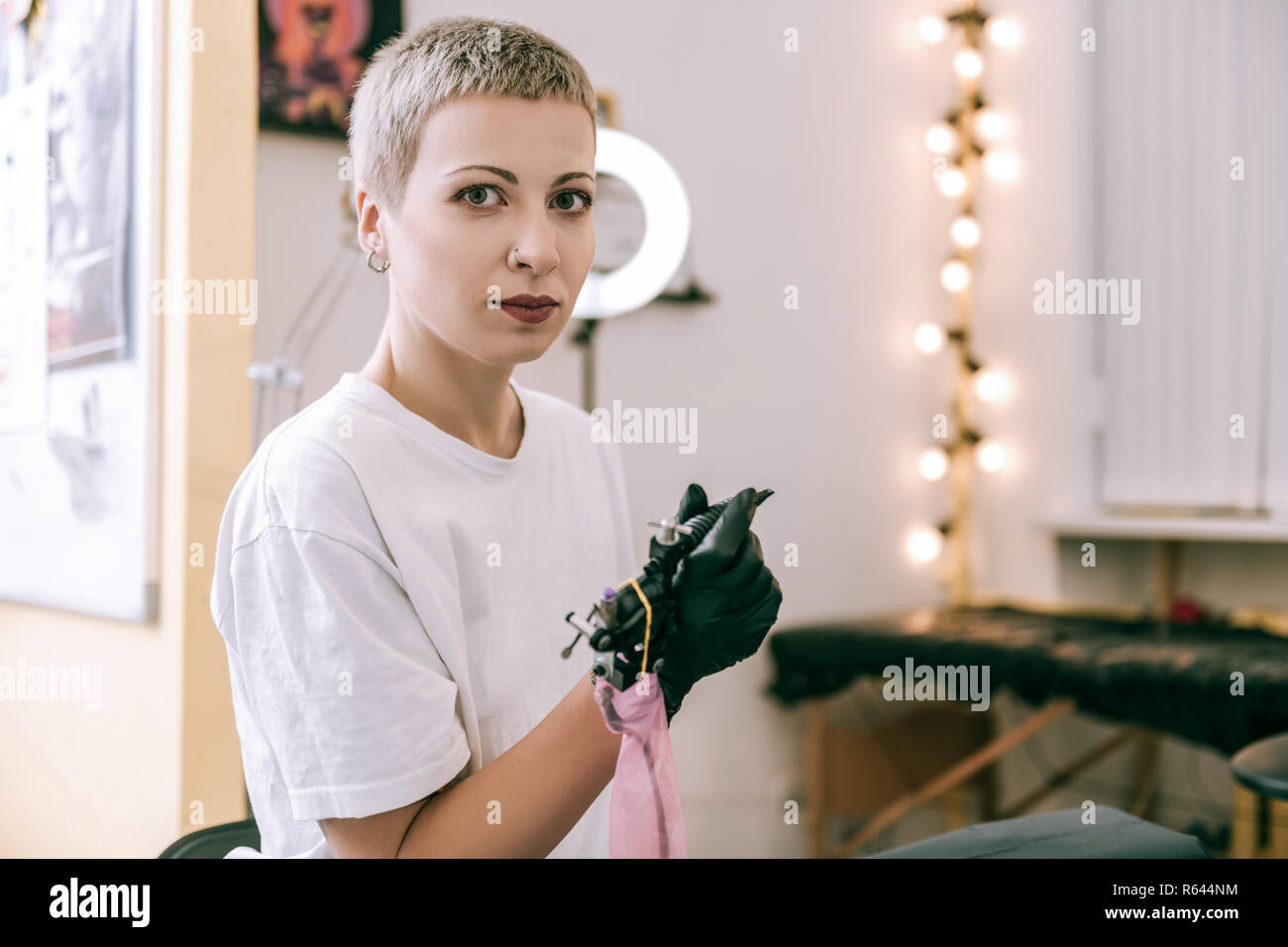 Exotic good-looking woman working as tattoo master Stock Photo - Alamy
