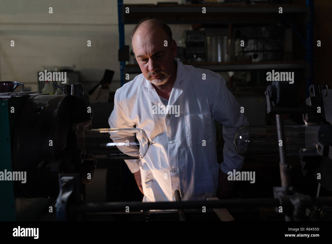 Male worker examining glass product in factory Stock Photo - Alamy