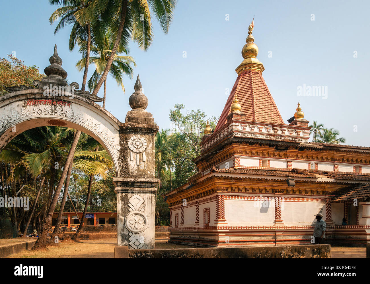 Morjim, Goa, India. Ancient Hindu Shree Morjai Temple amidst a coconut ...