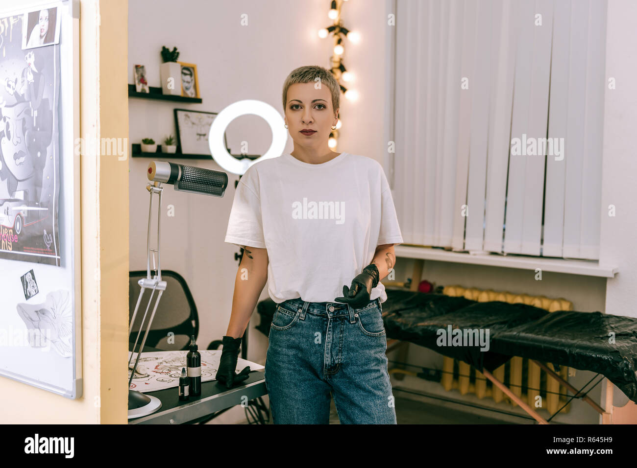 Good-looking tattoo master wearing plain white t-shirt and protective ...