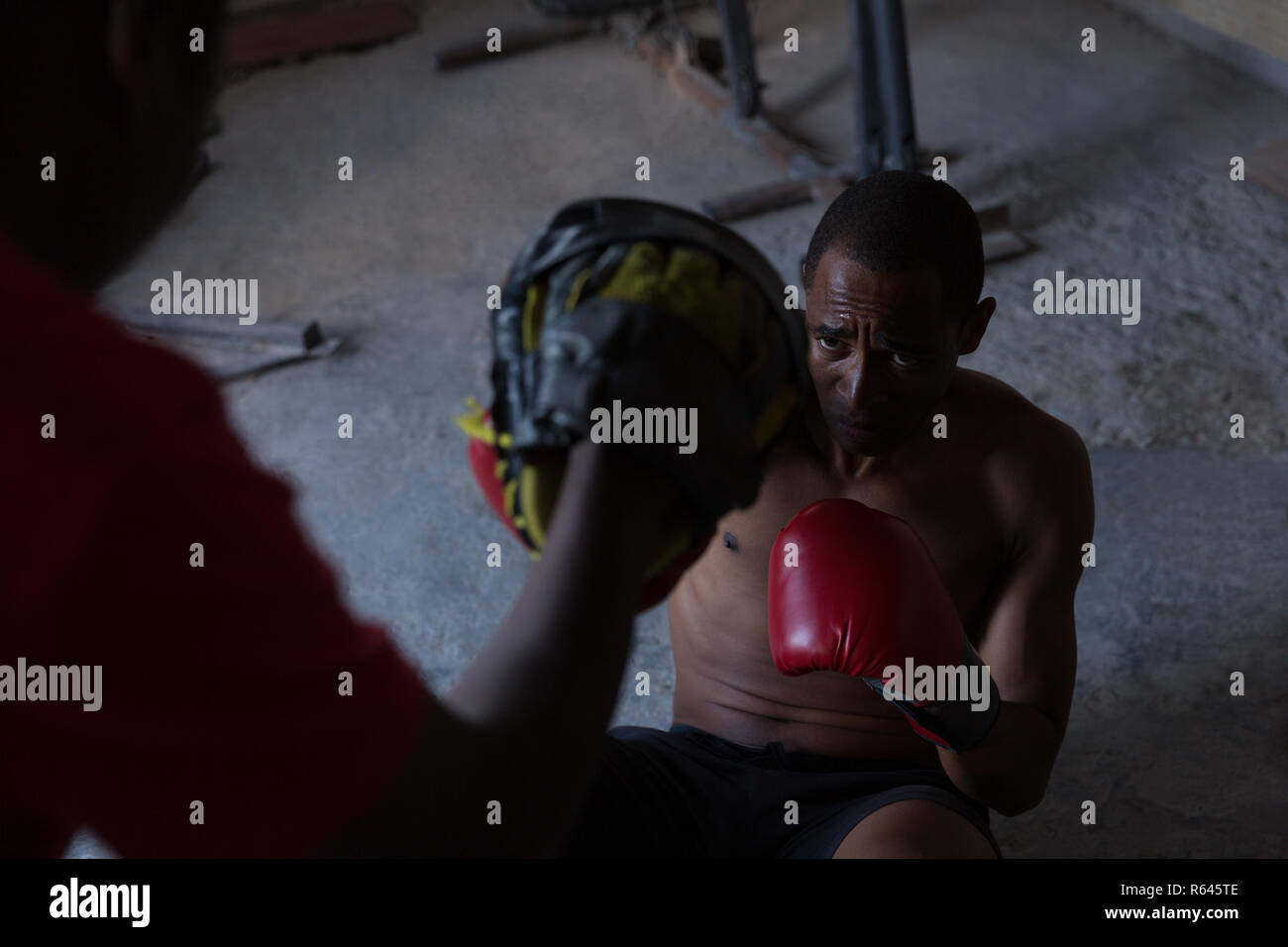 Trainer training male boxer in boxing club Stock Photo - Alamy