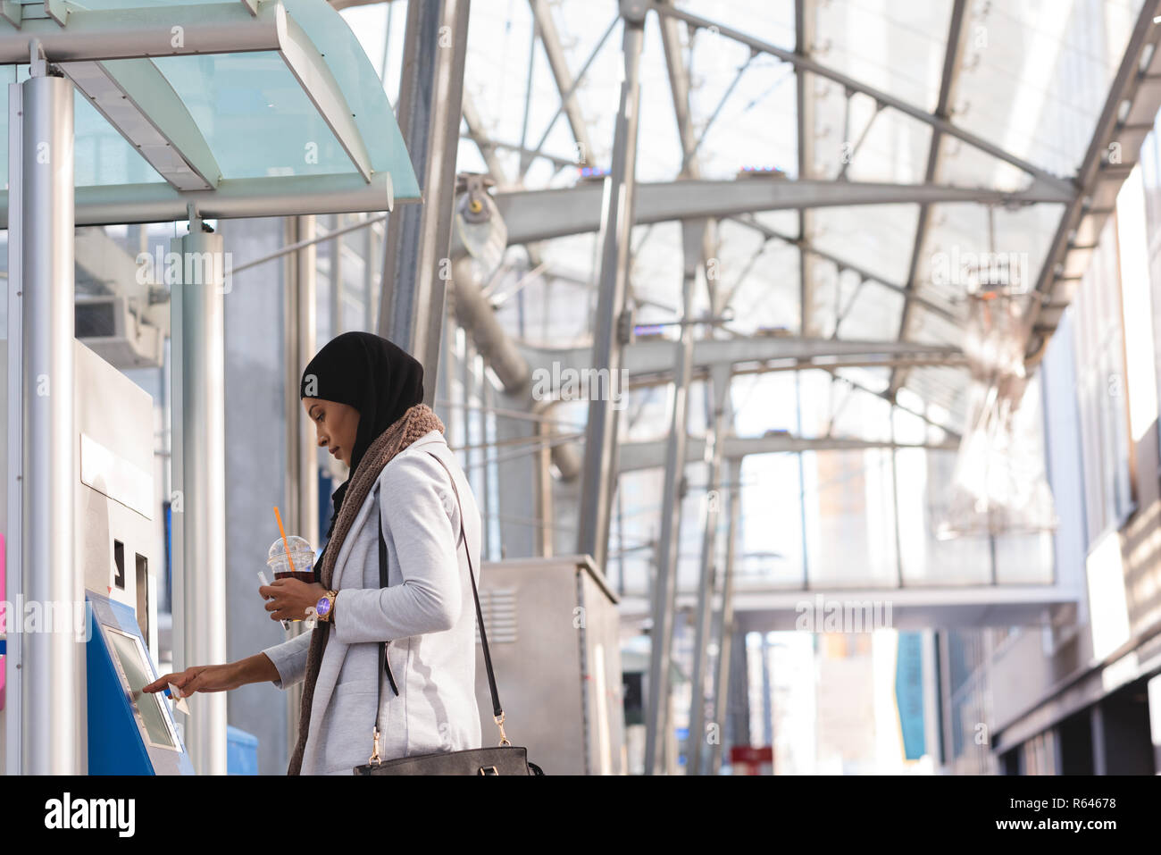 Hijab woman using ticket vending machine at railway station Stock Photo ...