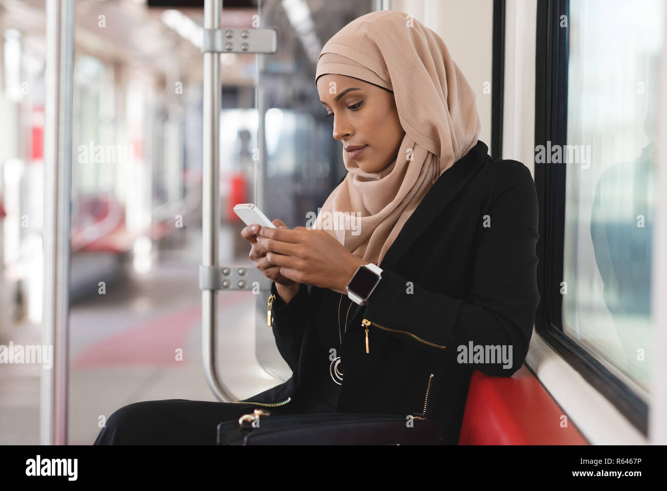 Woman using mobile phone while travelling in train Stock Photo - Alamy