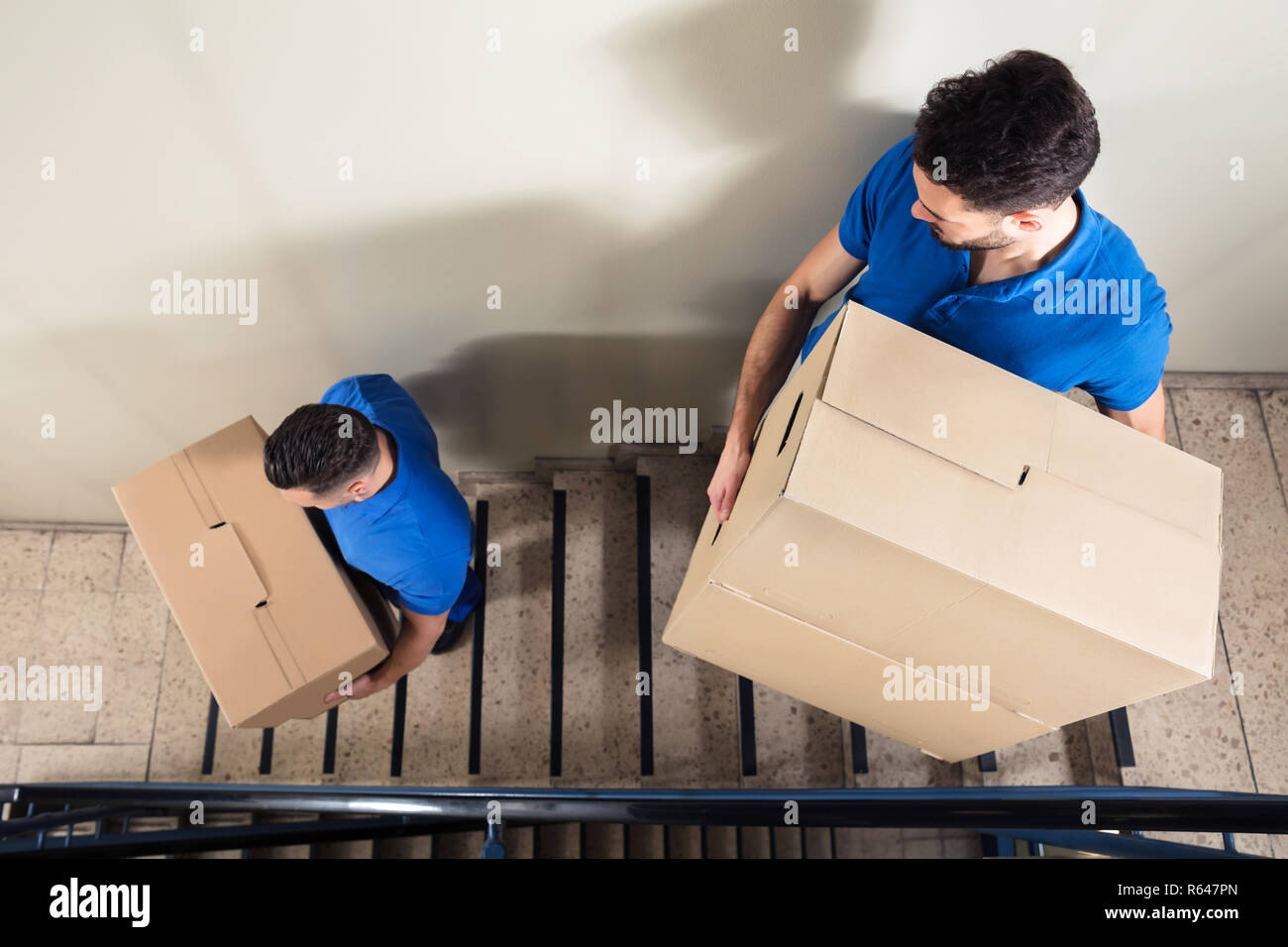 Two Movers Carrying Cardboard Boxes On Staircase Stock Photo - Alamy