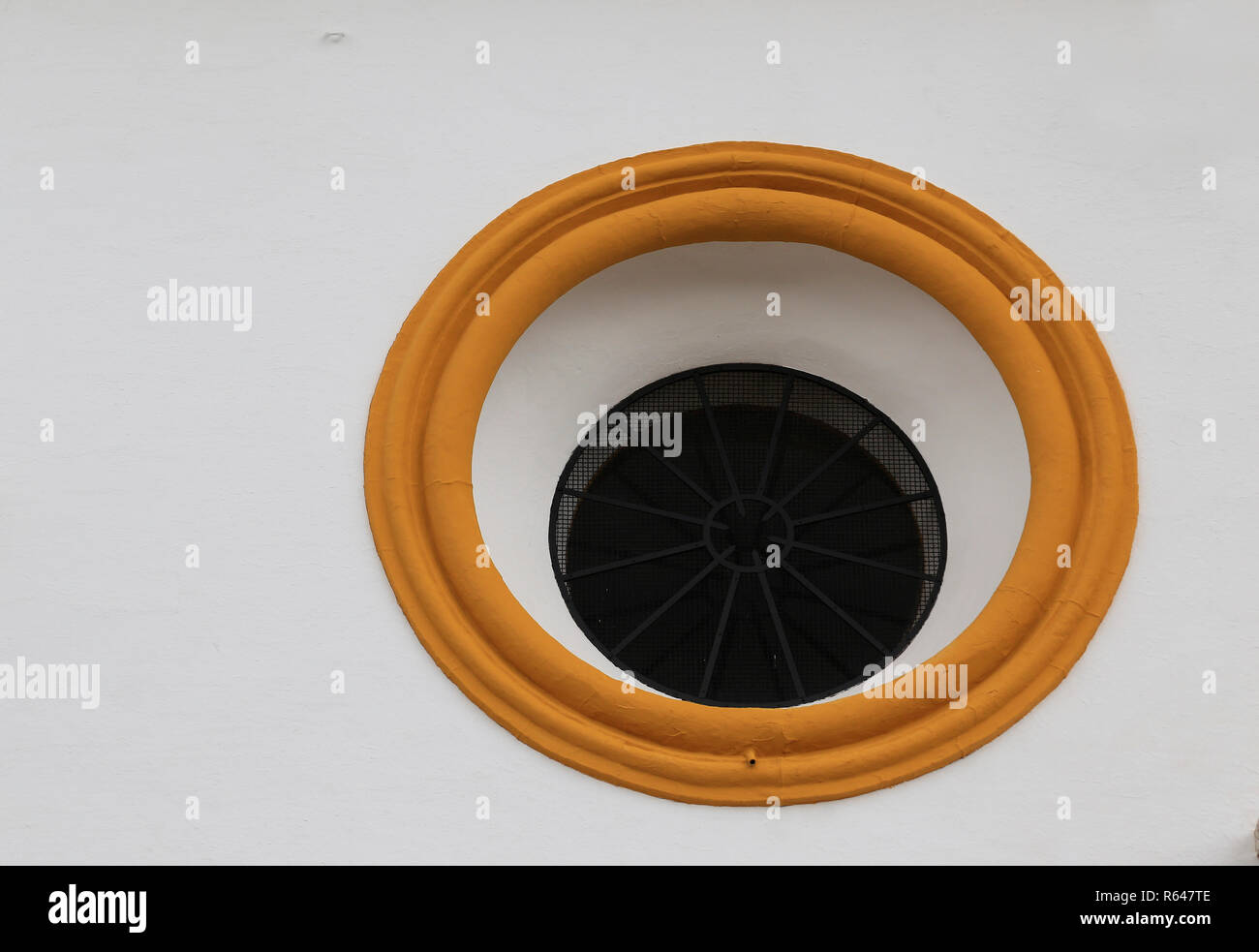 circular yellow ochre window in white wall Stock Photo - Alamy