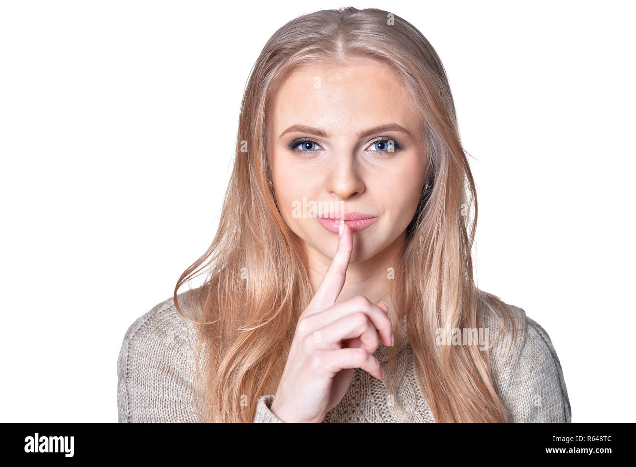 Portrait of young woman with silence gesture on white background Stock ...
