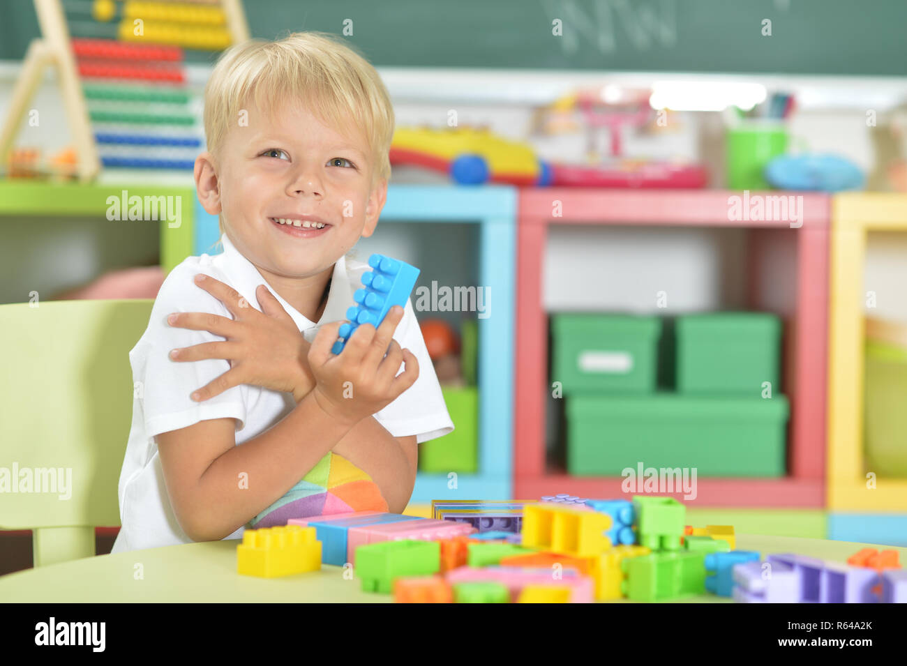 Portrait of cute little boy playing with colorful plastic blocks Stock ...