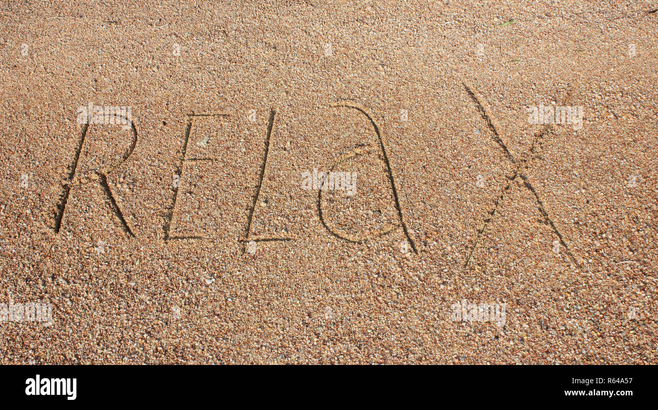 Relax text is written on sand Stock Photo - Alamy