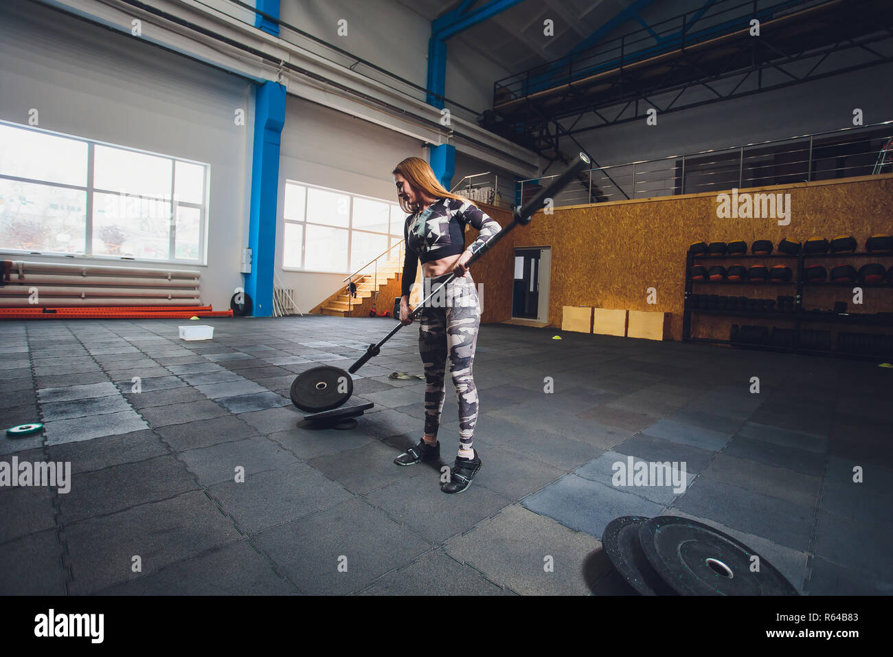 Attractive young sports woman with barbell. Deadlift. dropped the ...