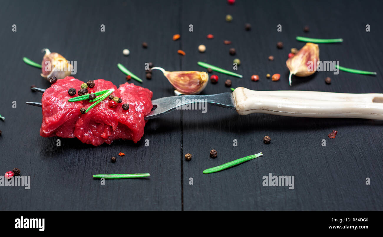 pieces of beef strung on a kitchen fork Stock Photo - Alamy
