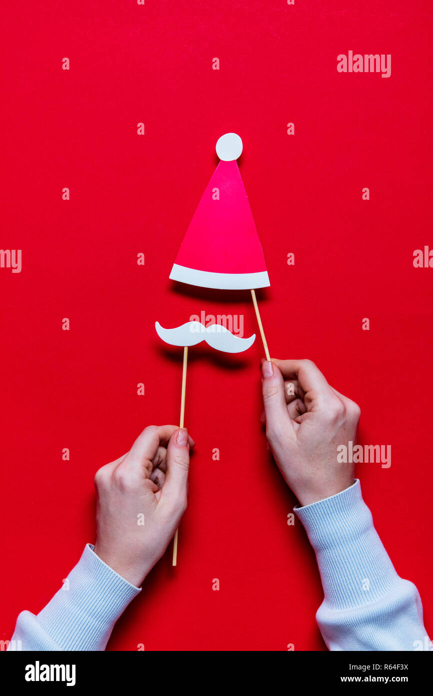 Hands holding Santa Claus Christmas photobooth props on a red ...